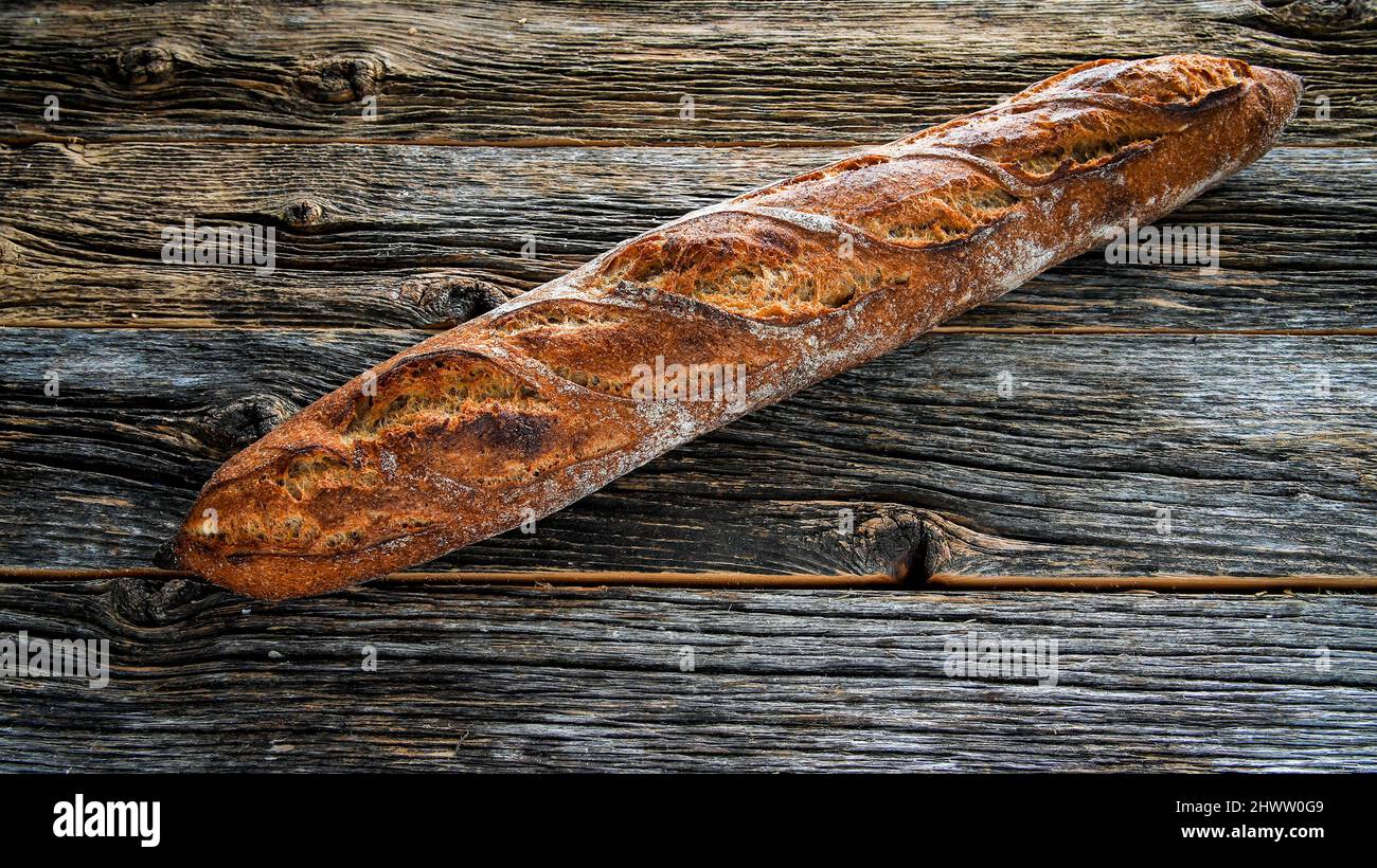 Baguette on rustic wooden table from above with copy space Stock Photo ...