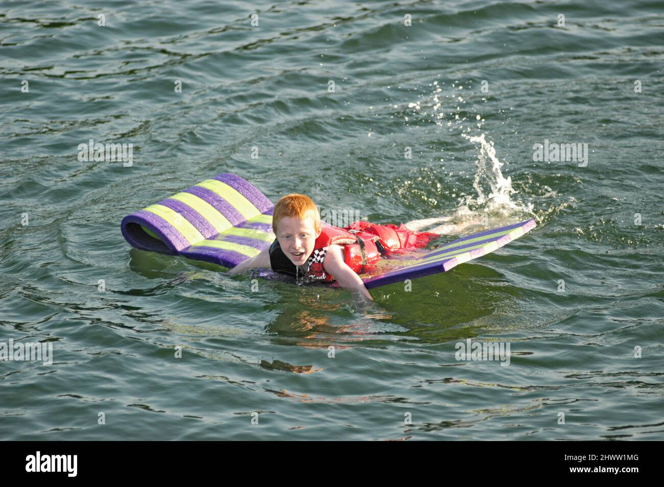 Kids playing on lake in inflatable rafts and tubs in the sun Stock ...