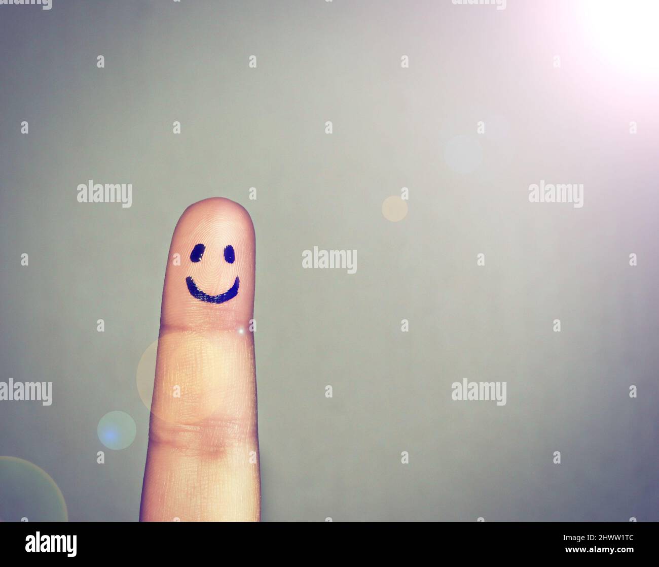 Get your happy face on. Shot of a finger with a happy face drawn on it ...