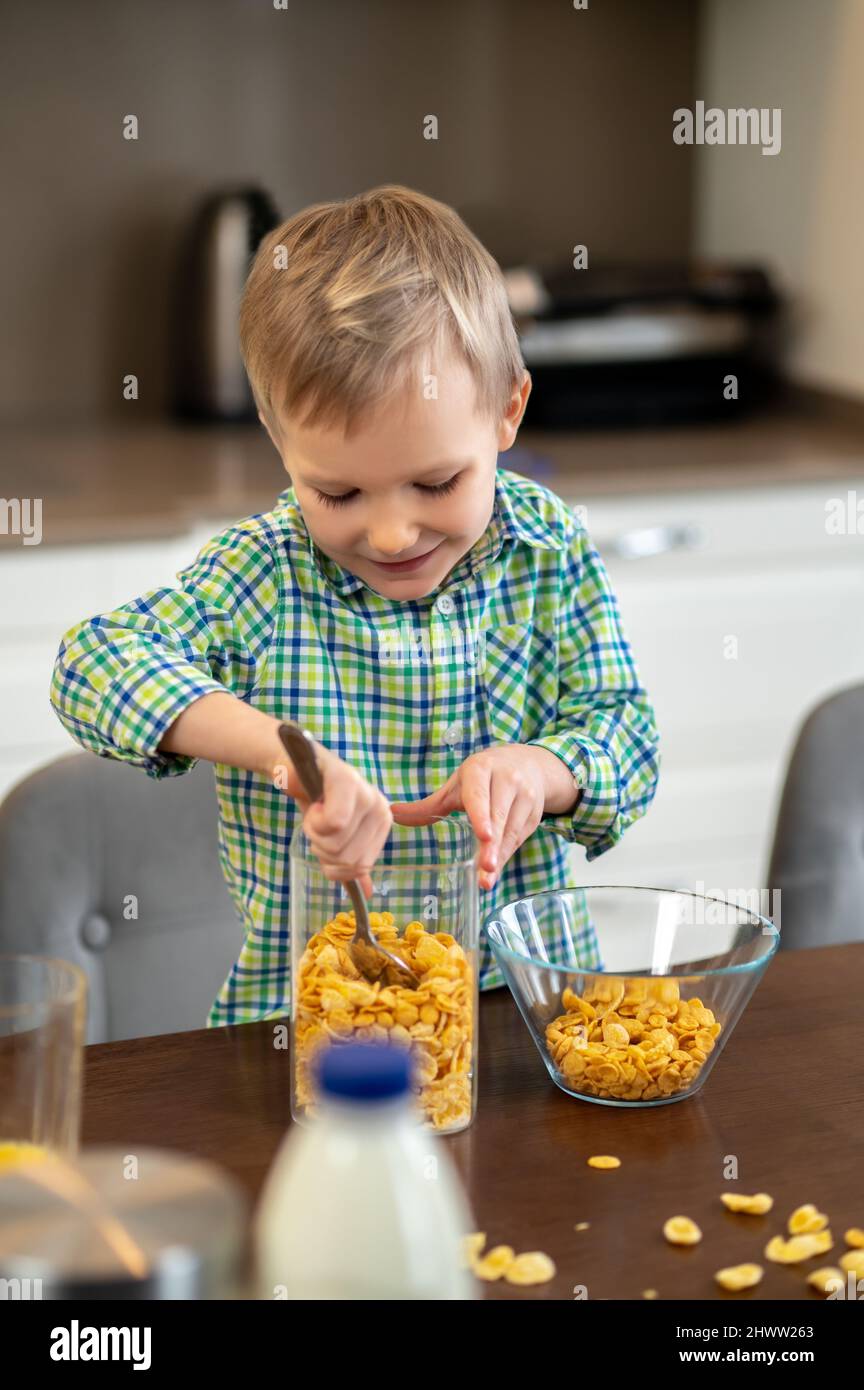 Joyous child scooping ingredients for an oatmeal dish Stock Photo - Alamy