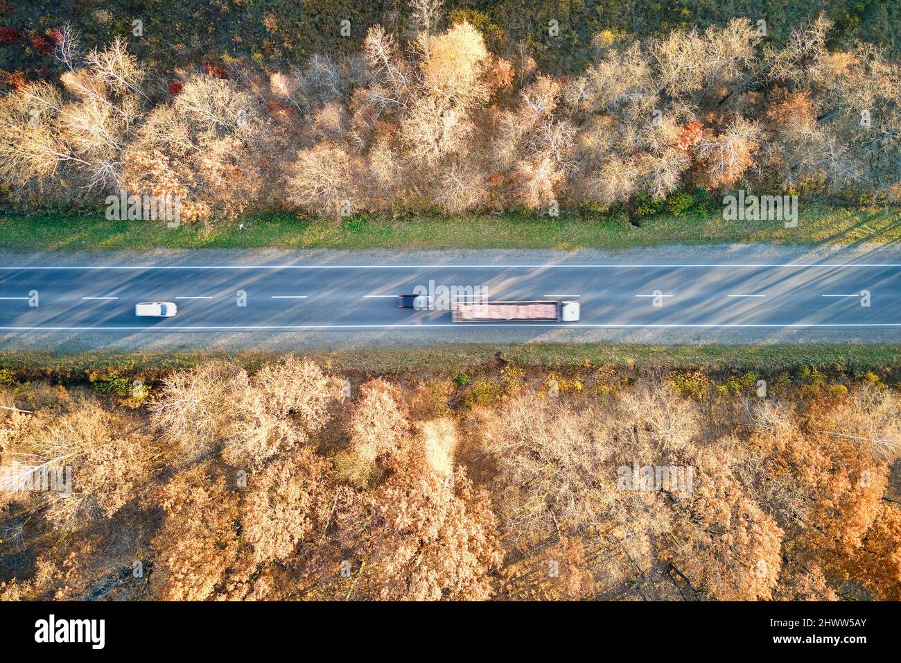 Aerial view of intercity road with fast driving cars between autumn ...
