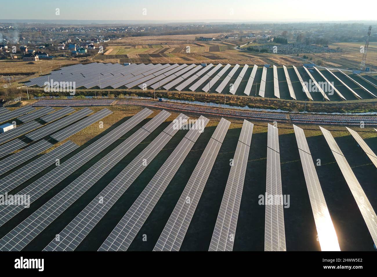 Aerial view of large sustainable electrical power plant with rows of solar photovoltaic panels ...