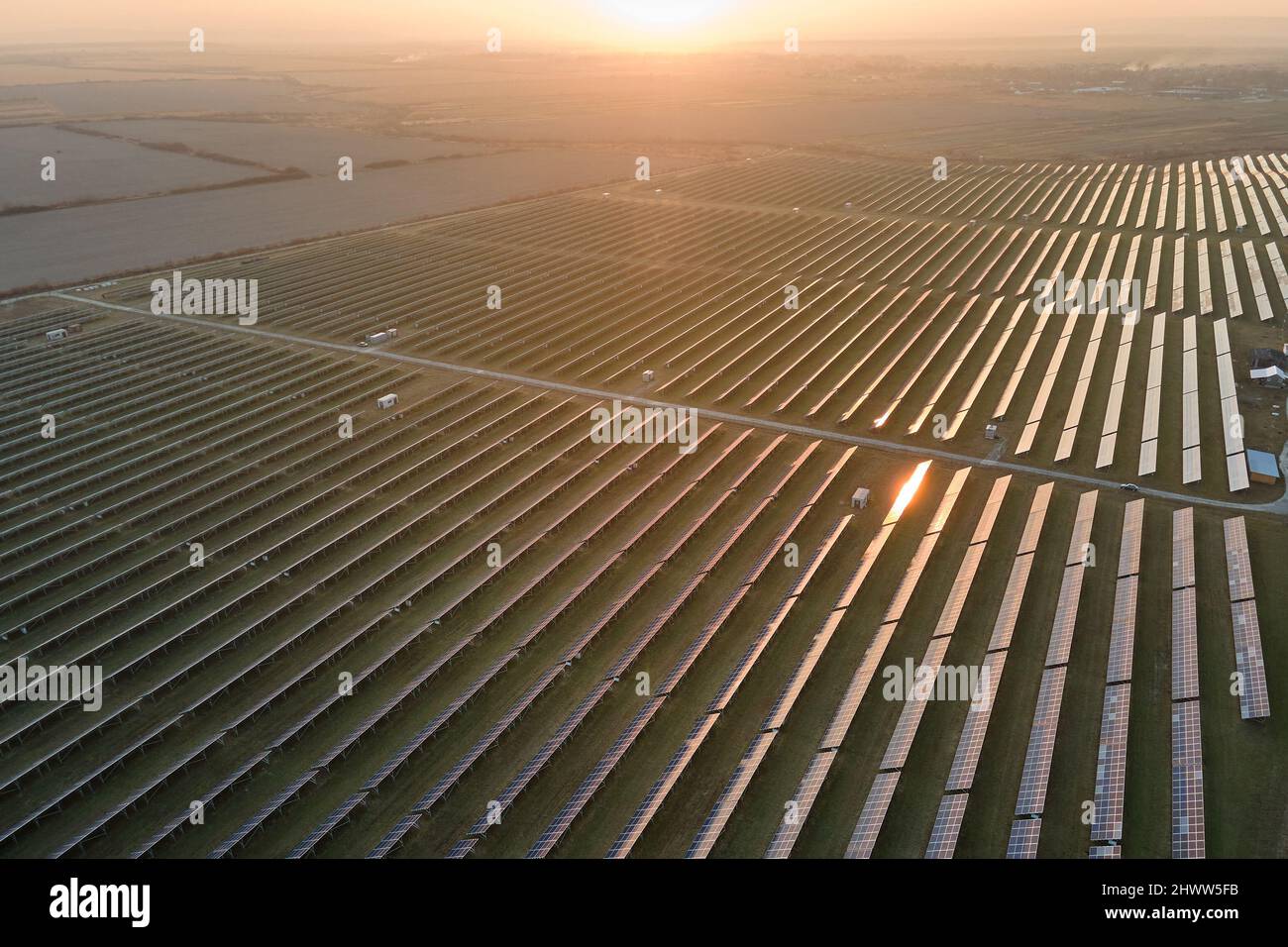 Aerial view of large sustainable electrical power plant with rows of solar photovoltaic panels ...