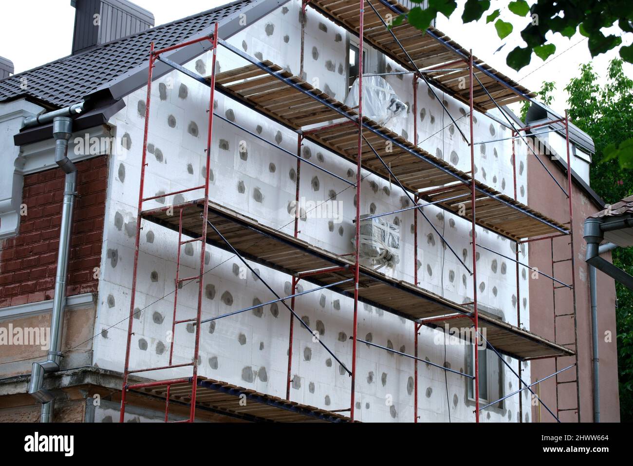 Building facade under renovation works with construction scaffolding ...