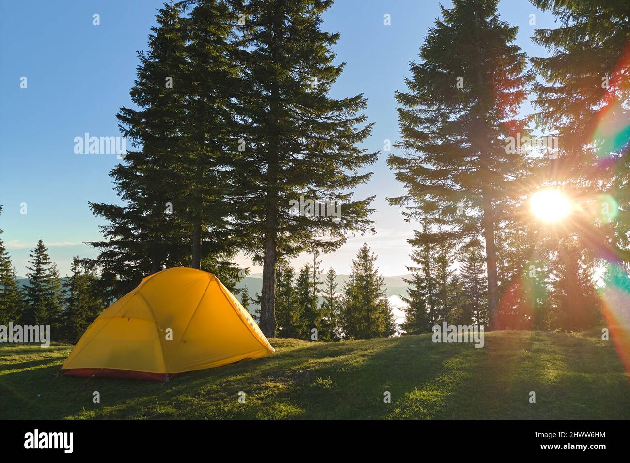 Tourist camping tent on mountain campsite at bright sunny evening ...