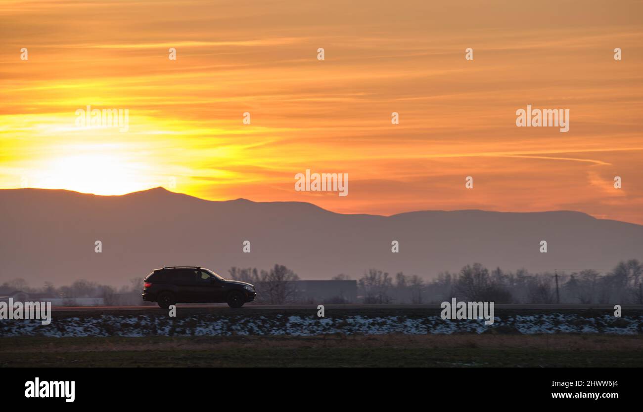 SUV car driving fast on intercity road at sunset. Highway traffic in ...