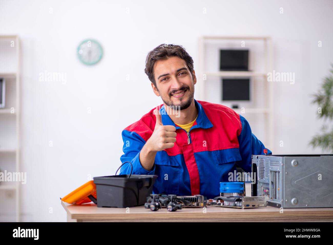 Young repairman repairing computer at workshop Stock Photo - Alamy