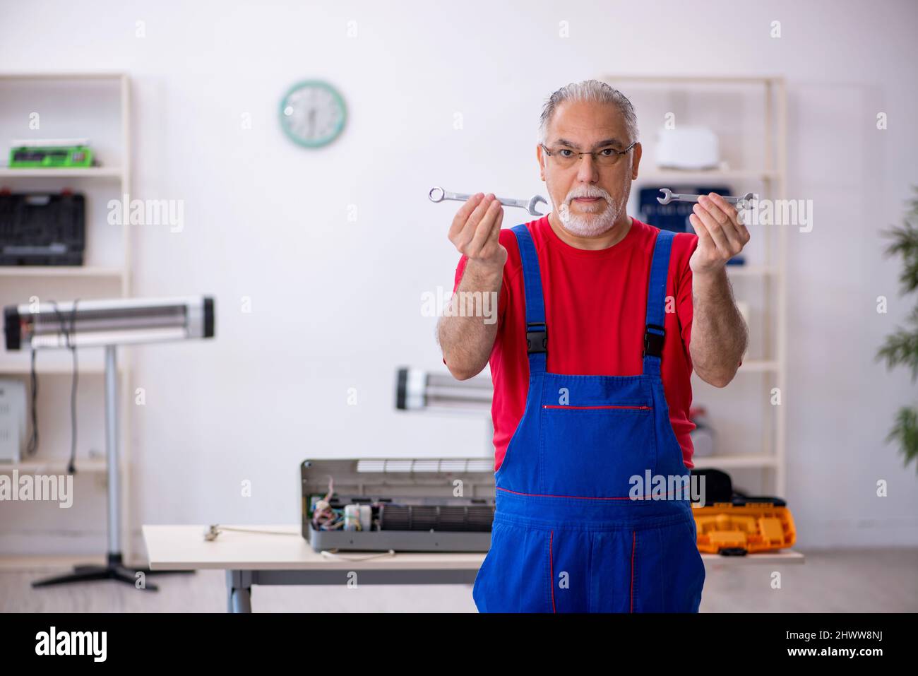 Old male repairman repairing air-conditioner Stock Photo - Alamy