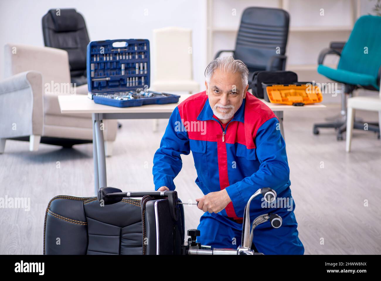 Old repairman repairing office chair Stock Photo - Alamy