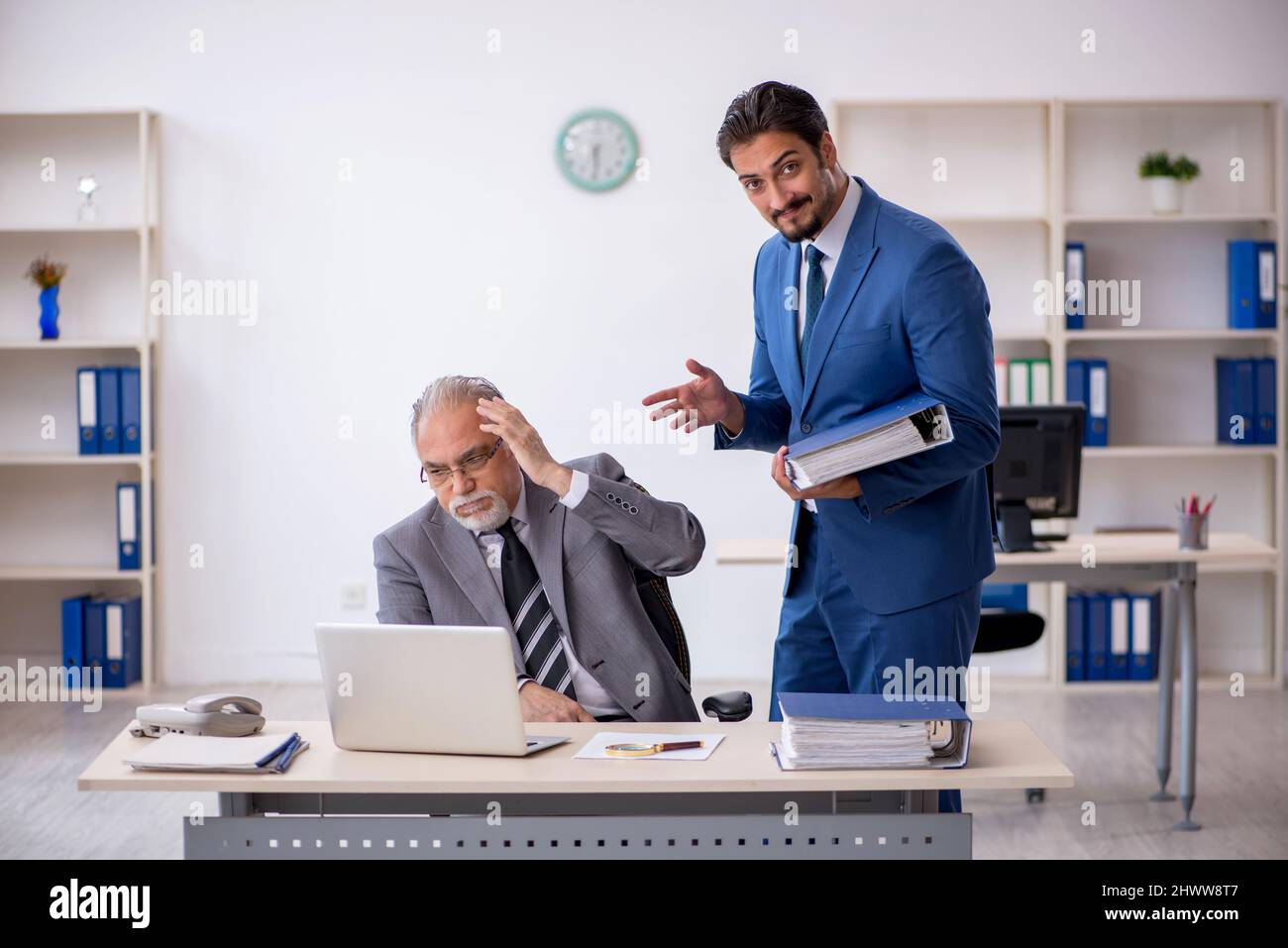 Old boss and young employee working at workplace Stock Photo - Alamy