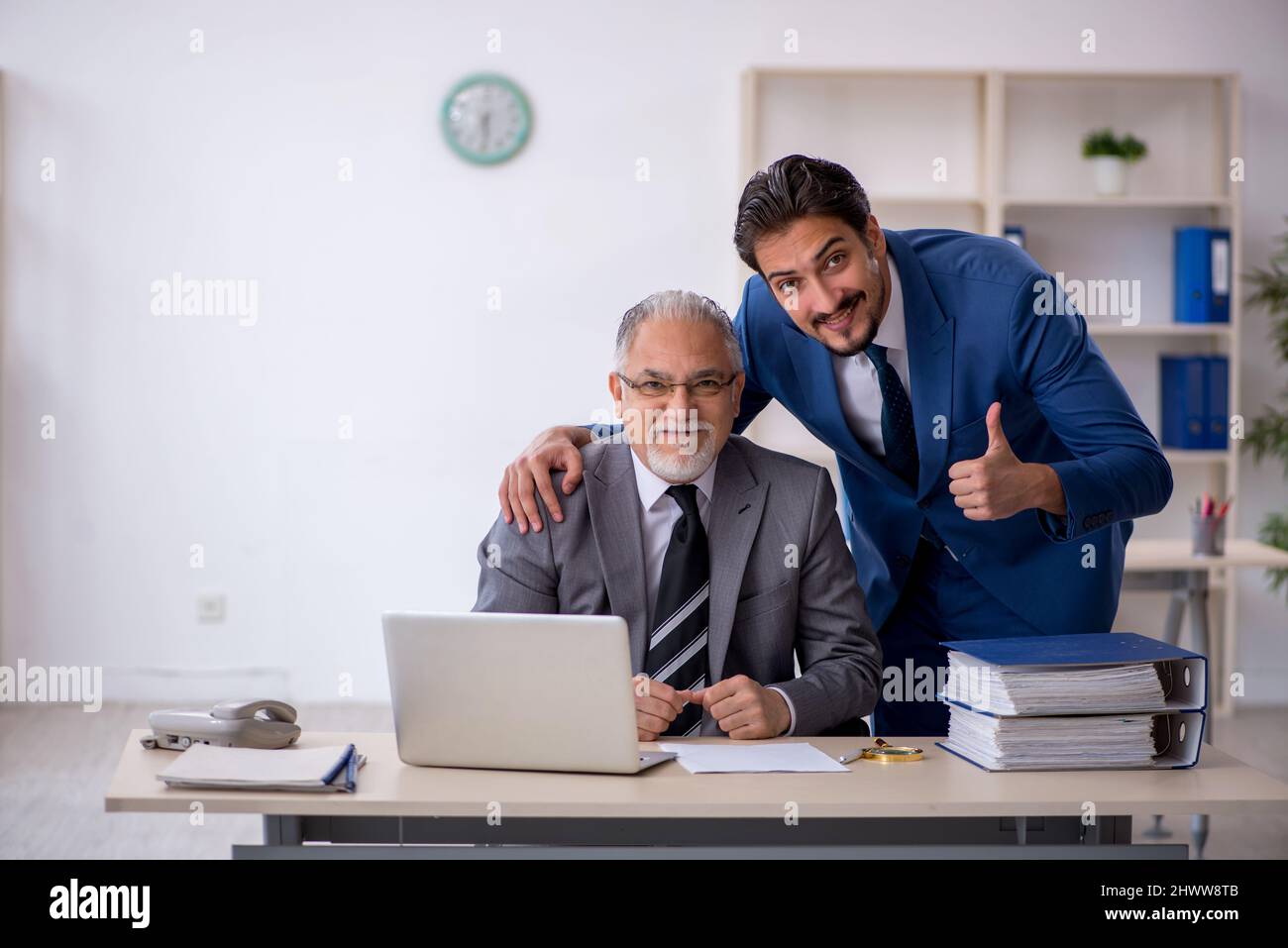 Old boss and young employee working at workplace Stock Photo - Alamy