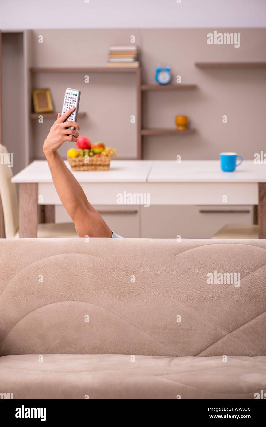 Young male student watching tv at home Stock Photo - Alamy