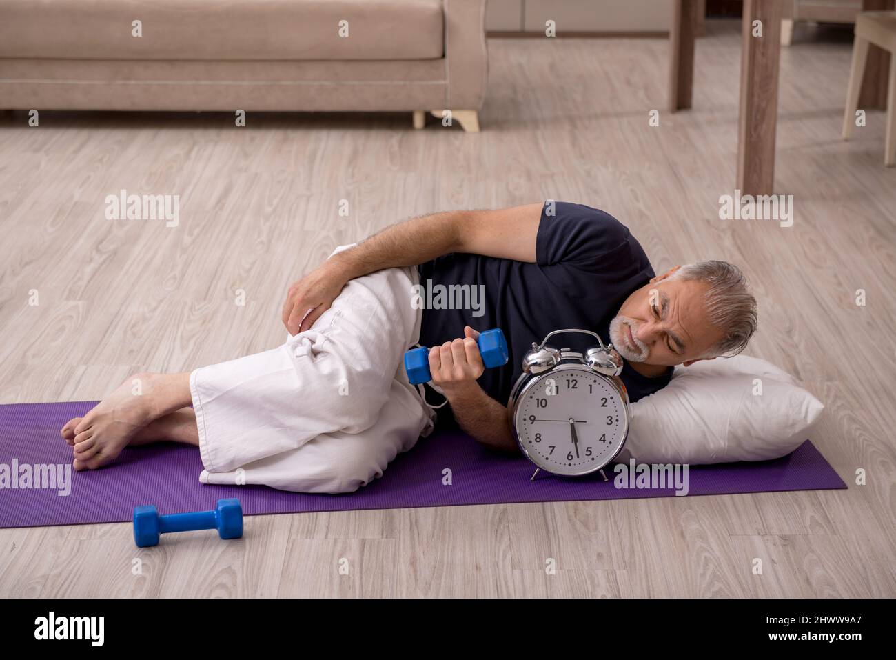 Old man doing sport exercises indoors Stock Photo - Alamy