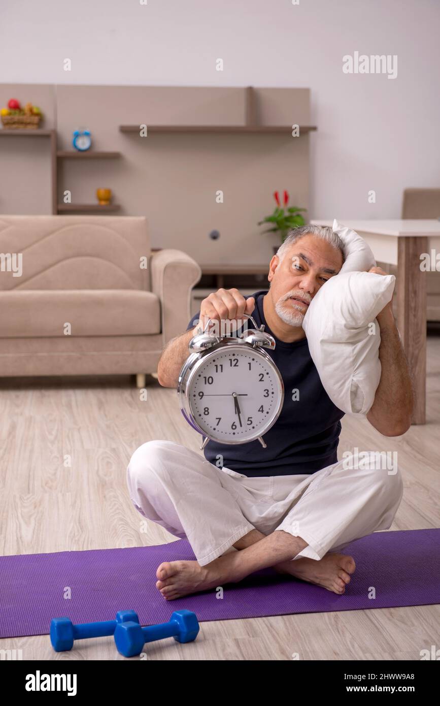 Old man doing sport exercises indoors Stock Photo - Alamy