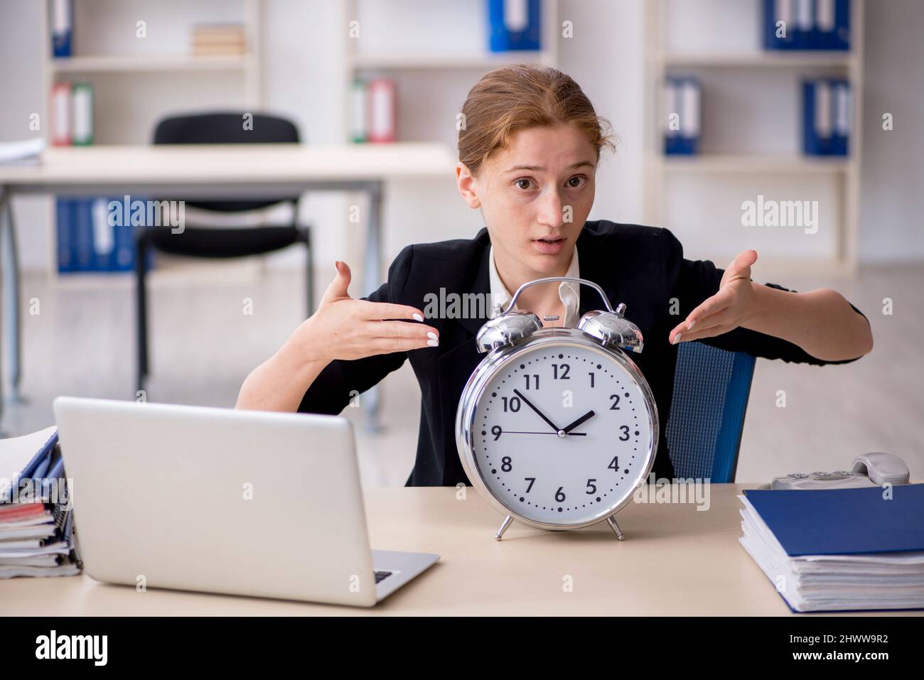 Female employee in time management concept Stock Photo - Alamy