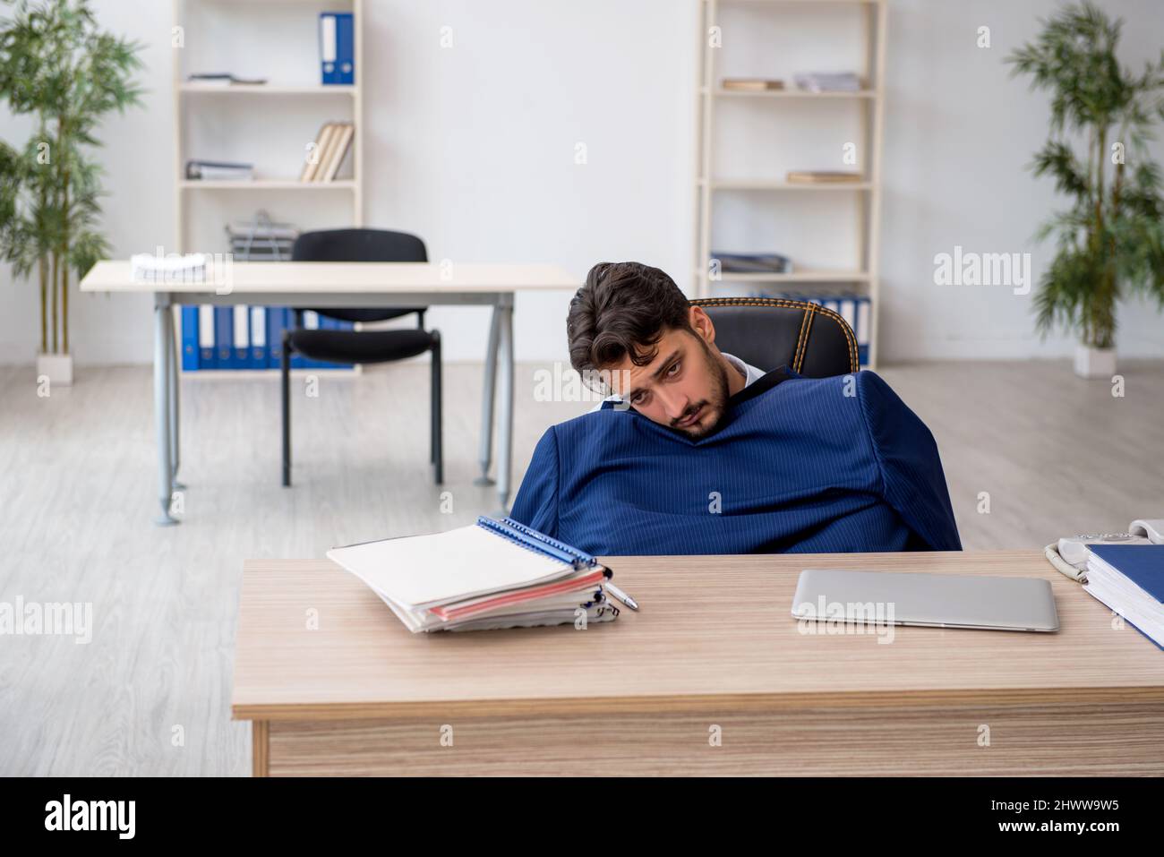 Young businessman employee extremely tired at workplace Stock Photo - Alamy