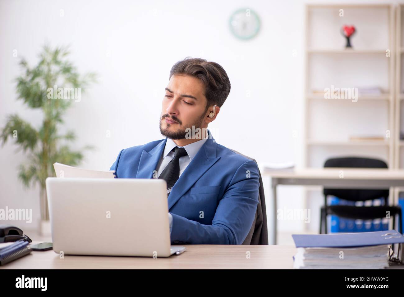 Deaf businessman employee using hearing aid in the office Stock Photo ...
