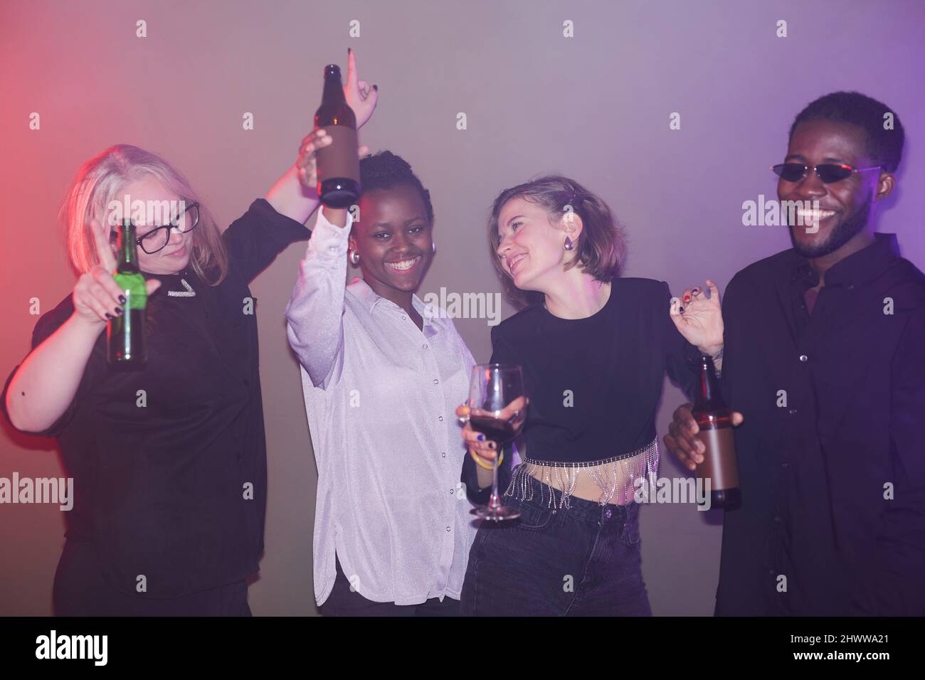 Hazy shot of diverse people dancing at party against minimal background ...