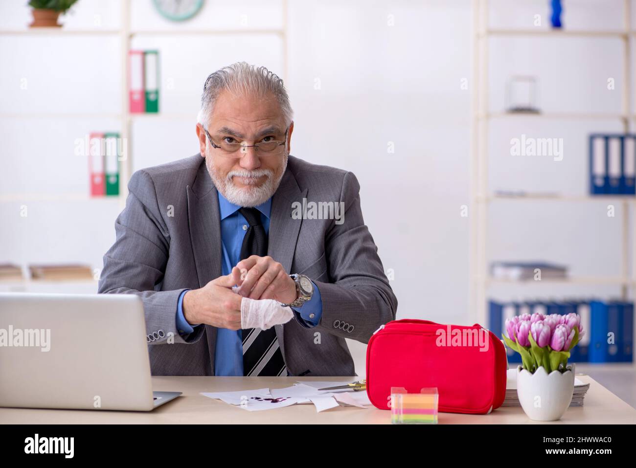 Old businessman employee cutting his hand at workplace Stock Photo - Alamy