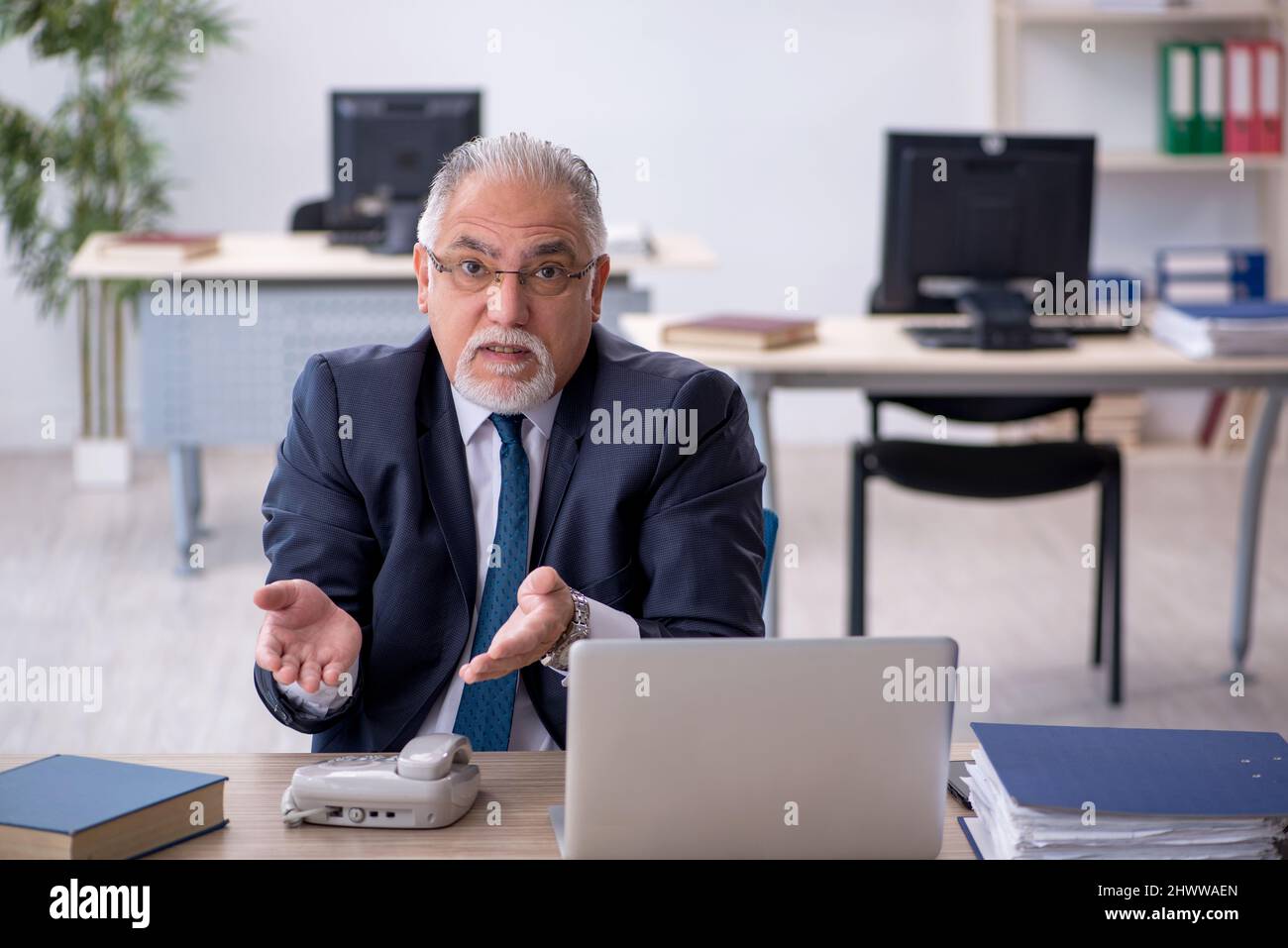 Old businessman employee speaking on the phone in the office Stock ...