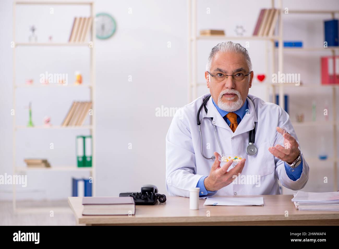 Old doctor working in the clinic Stock Photo - Alamy