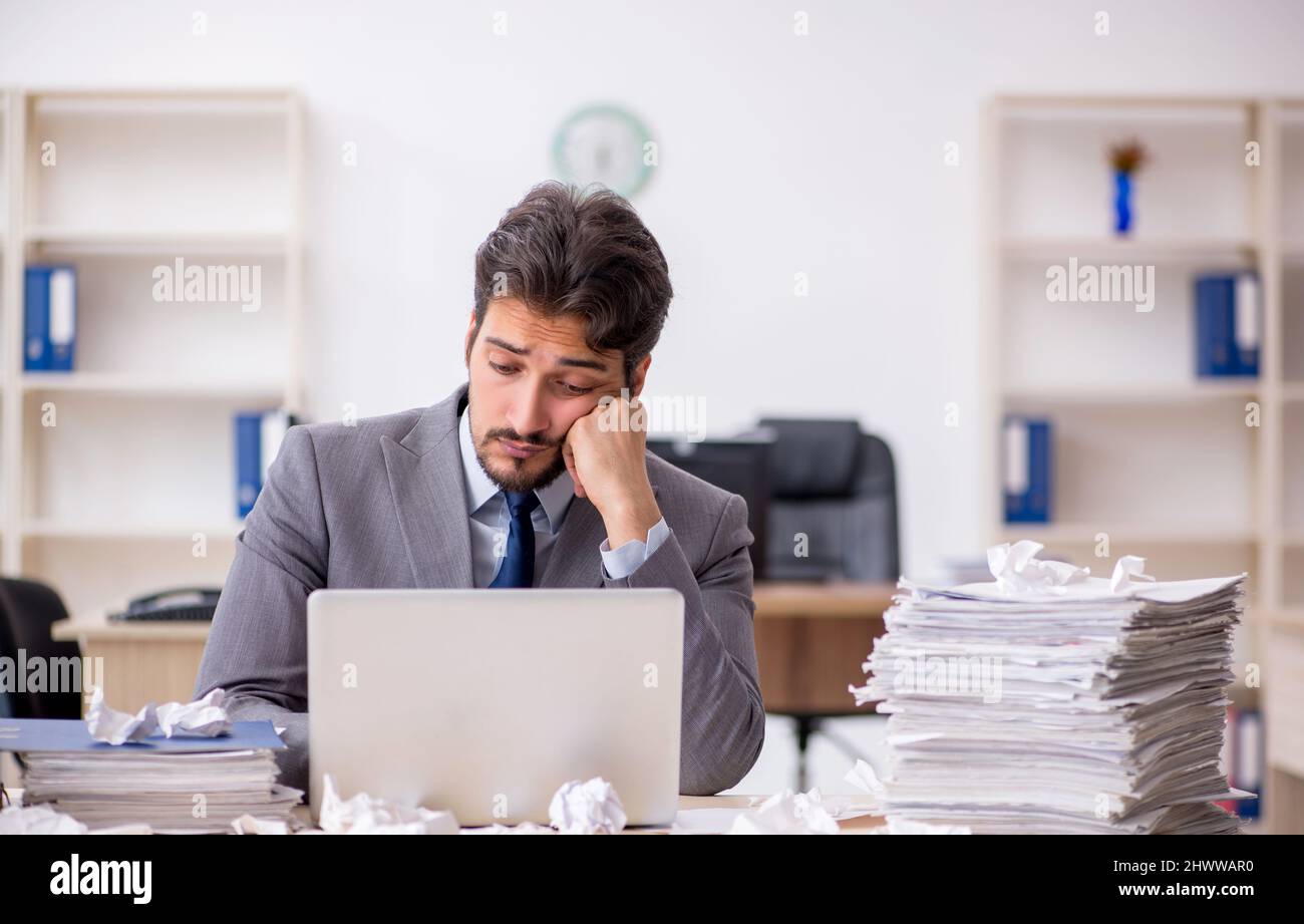 Young employee and too much work in the office Stock Photo - Alamy