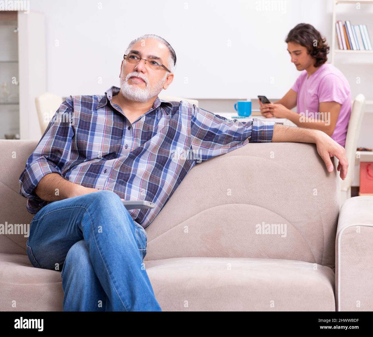 The young student and his old grandpa at home Stock Photo - Alamy
