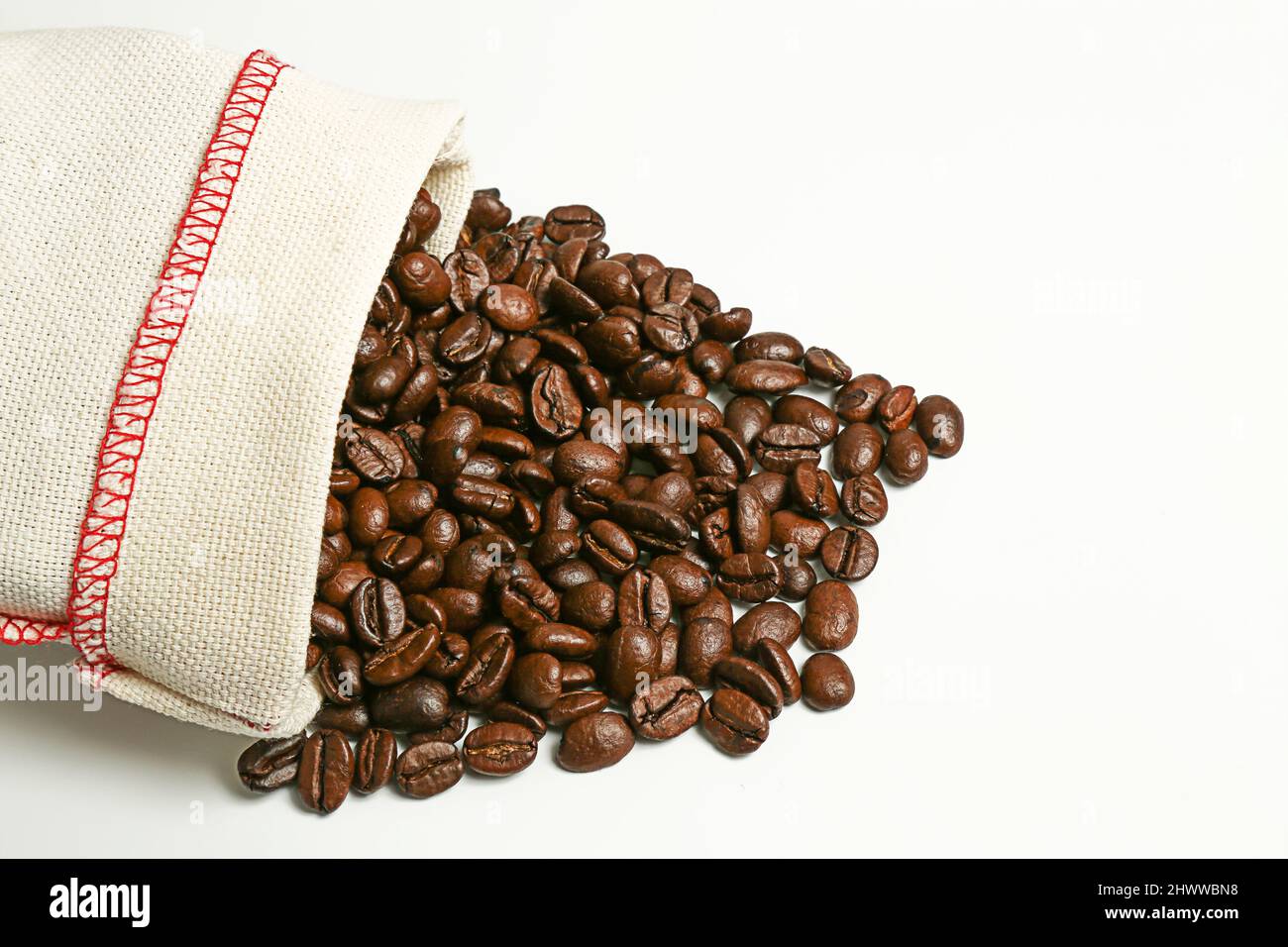 Coffee beans spilled out of the bag on a white background. Isolate ...