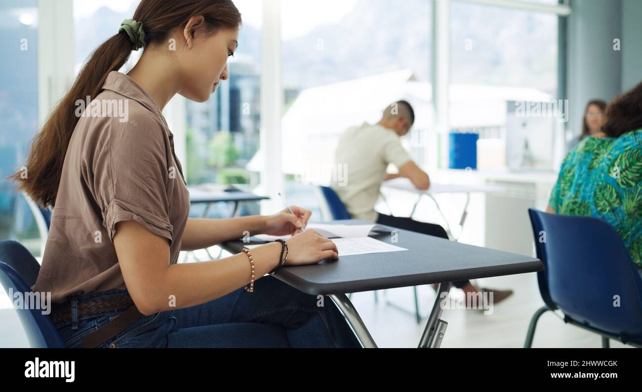 All tomorrow has to offer. Shot of a young student completing her exam ...