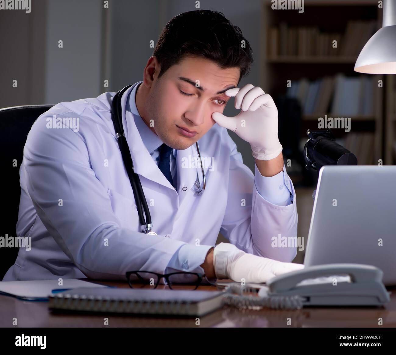 The young doctor working late in the office Stock Photo - Alamy