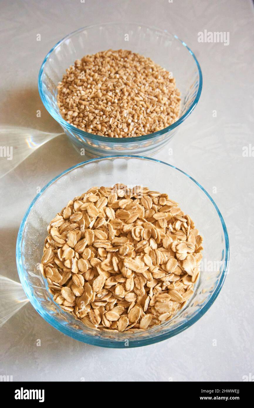 Two glass bowls of whole grain oats and steel cut oats Stock Photo - Alamy