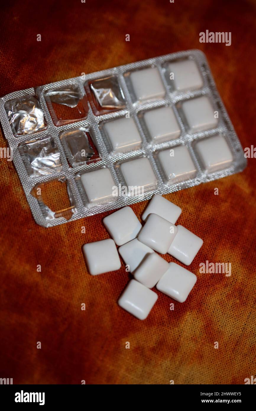 White nicotine square bubble gums close up smoking mania background ...