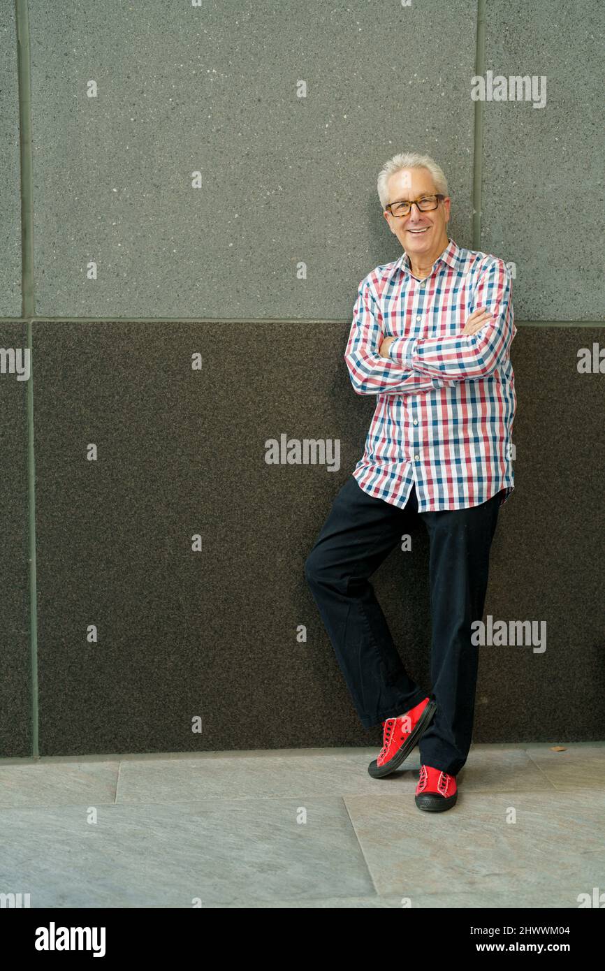 Hip old guy leaning on the wall Stock Photo - Alamy