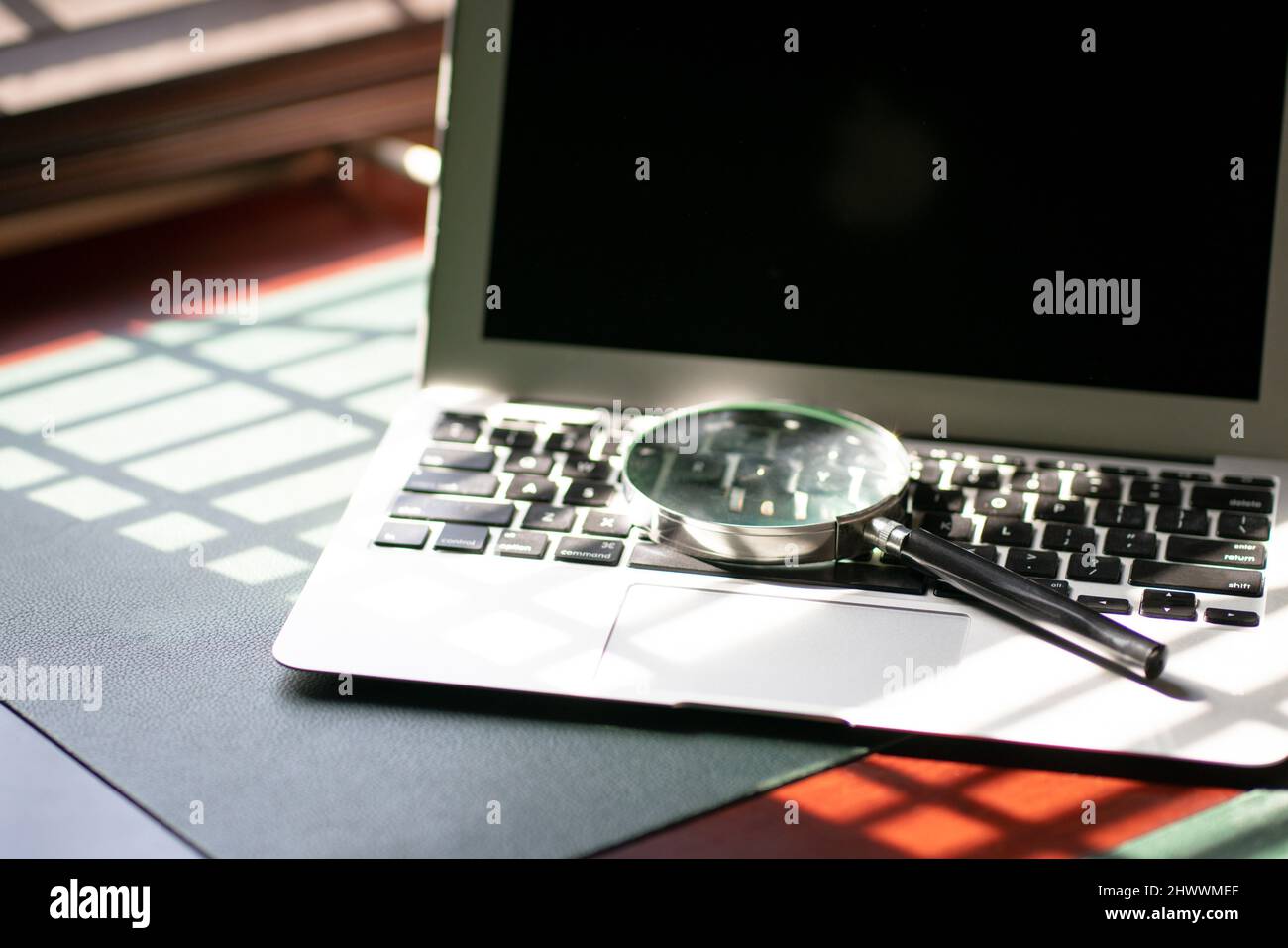 Magnifying glass on top of computer laptop. Online or internet search ...