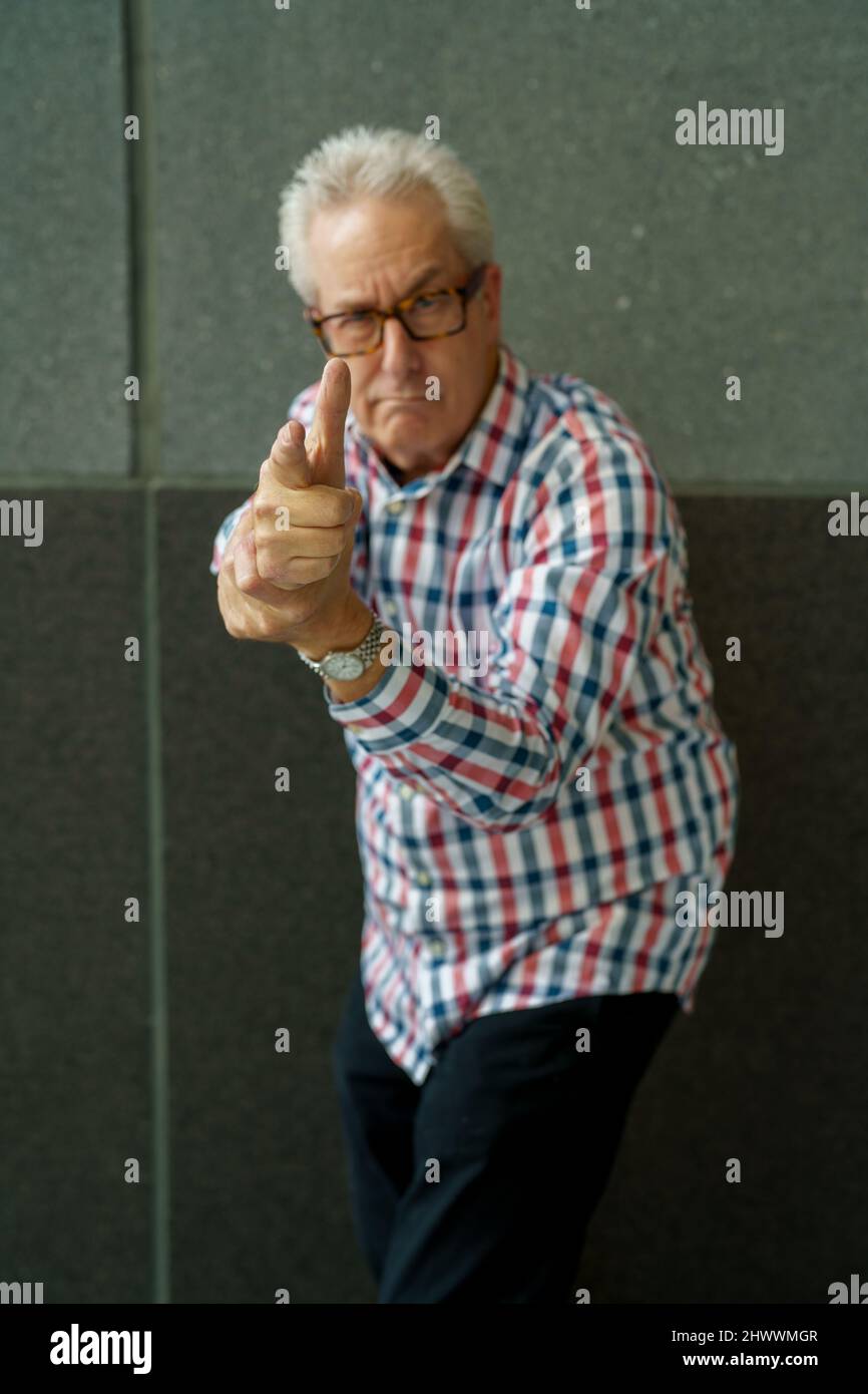 Old man with angry expression pointing a fake hand gun Stock Photo - Alamy
