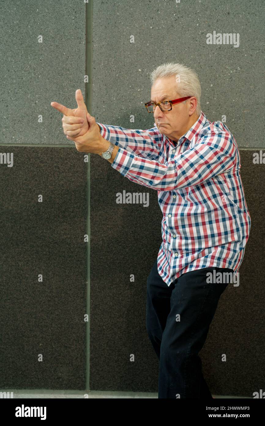 Man pointing fake finger gun away from camera Stock Photo - Alamy