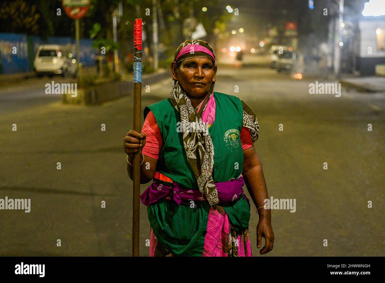 Halima, a cleaning worker of the city corporation, poses for a photo with a broom in hand at a ...