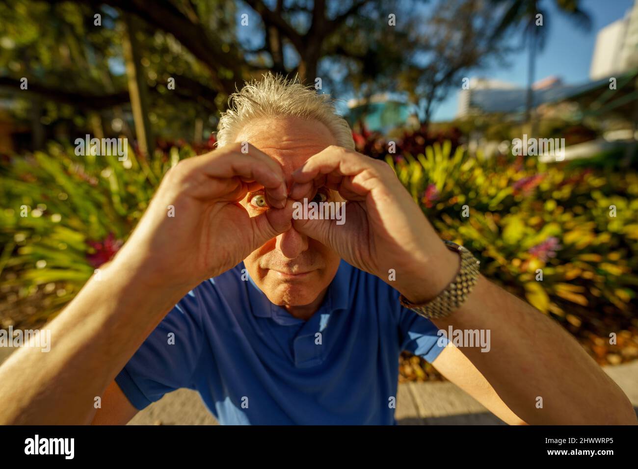 Man pretending to look through hand binoculars Stock Photo - Alamy