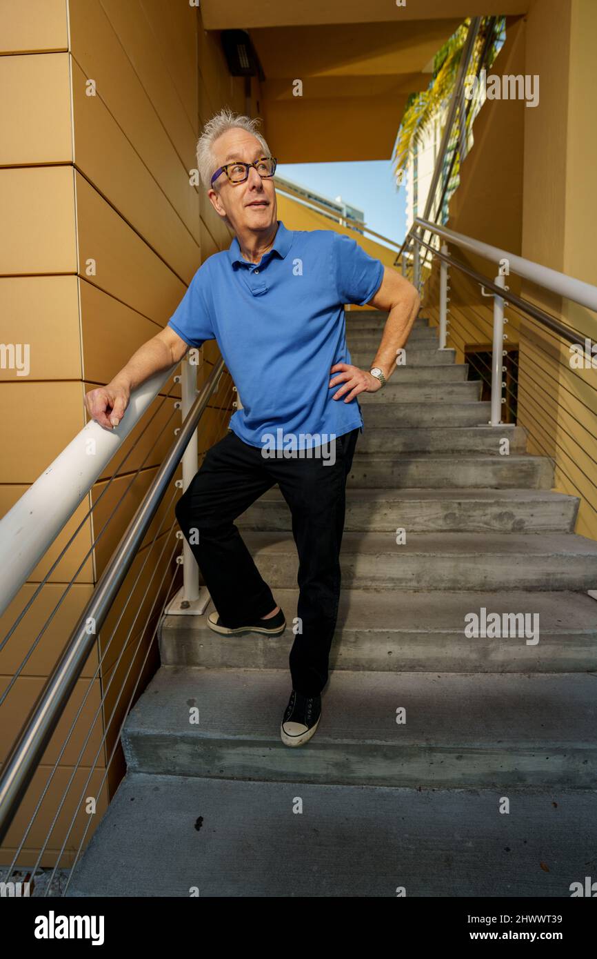 Man posing by a handrail staircase Stock Photo - Alamy