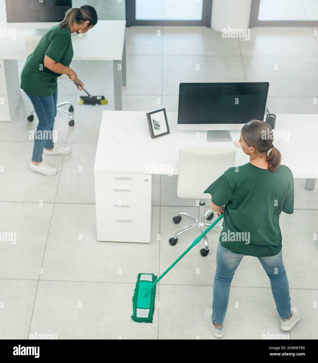 Workplace hygiene is everybodys business. High angle shot of two young ...