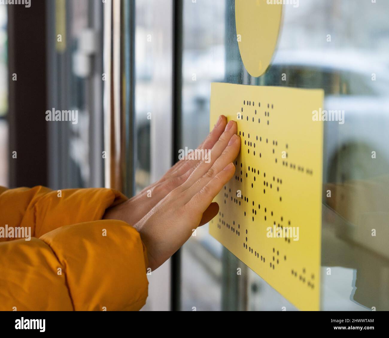 Close-up of a woman reading a braille lettering on a glass door Stock ...