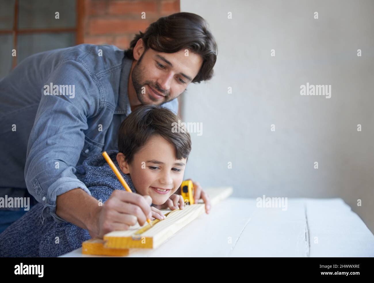 Let me show you what to do.... A father and son doing woodwork together ...