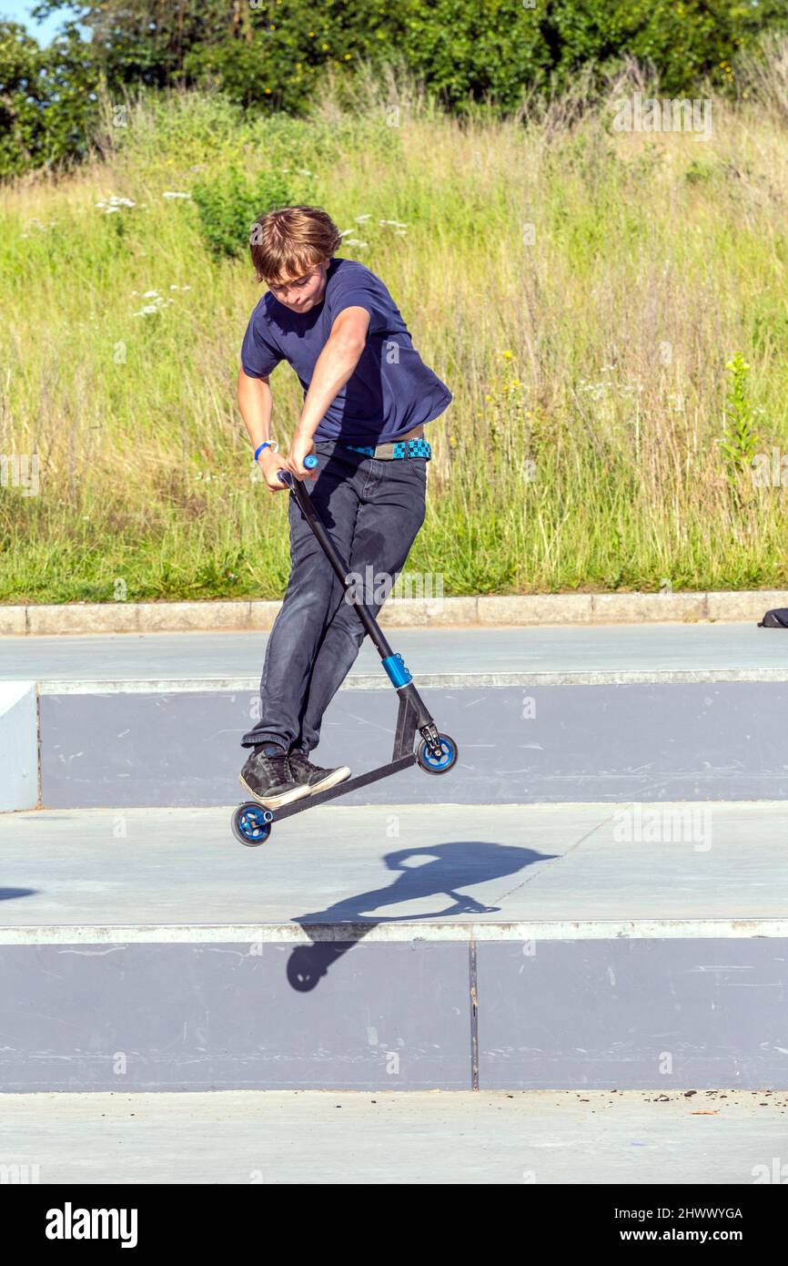 boy has fun riding his push scooter at the skatepark Stock Photo - Alamy
