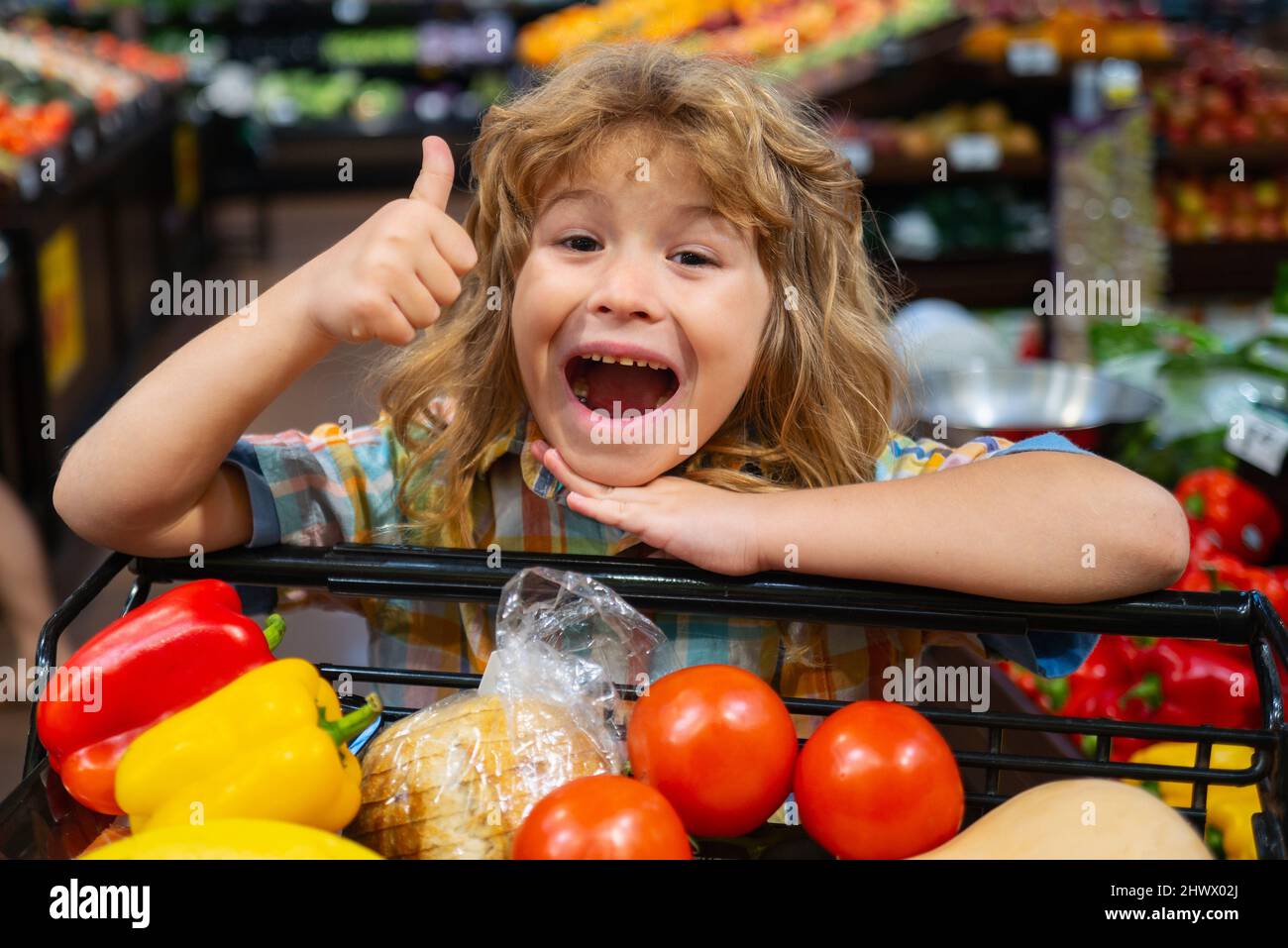 Sale, consumerism and child. Excited kid with food in shopping cart at ...