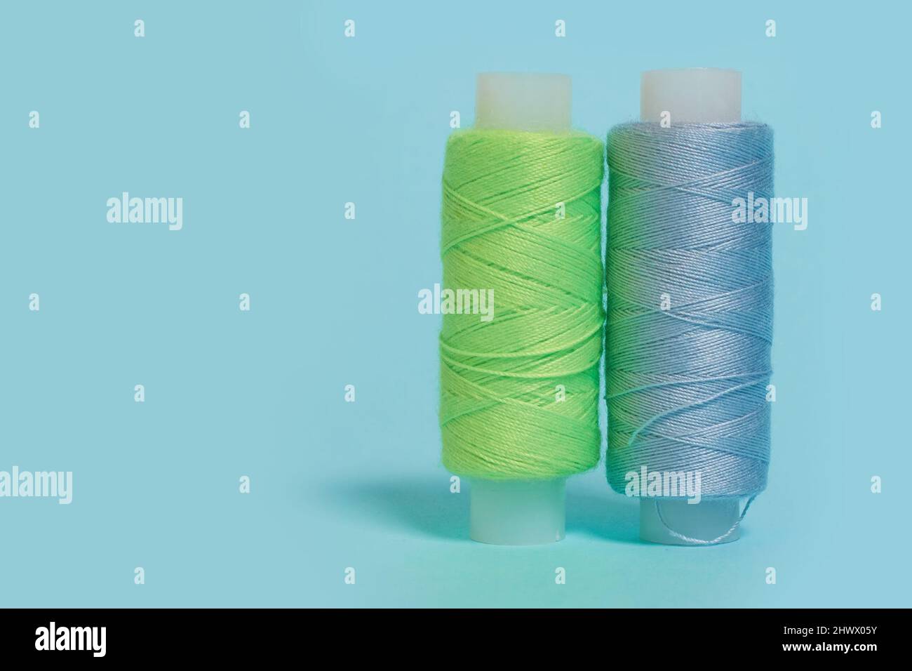 Coils with blue and green threads on a blue background Stock Photo - Alamy