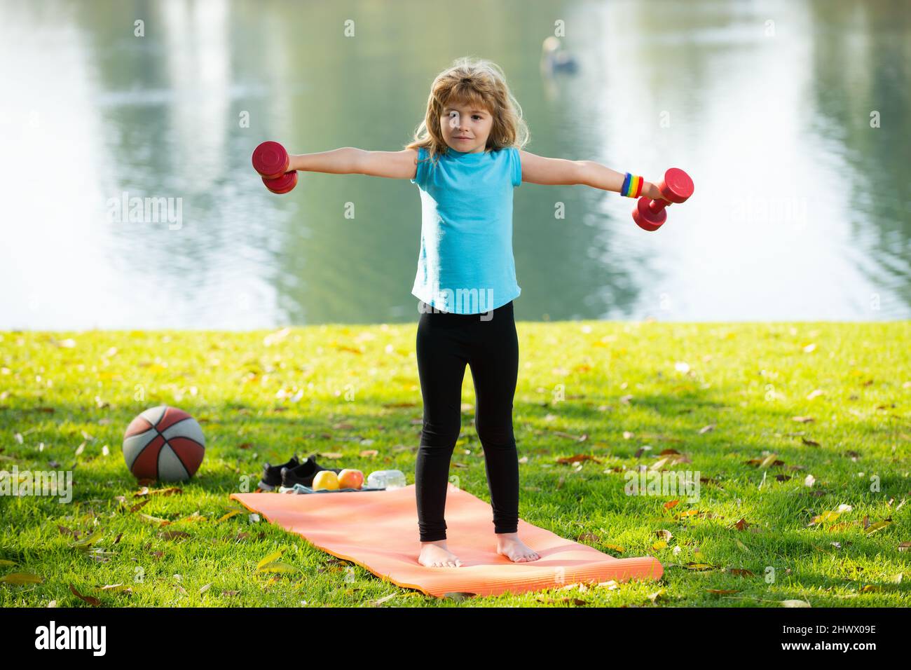 Kids sport. Healthy kid boy with dumbbell exercise outdoor. Little ...