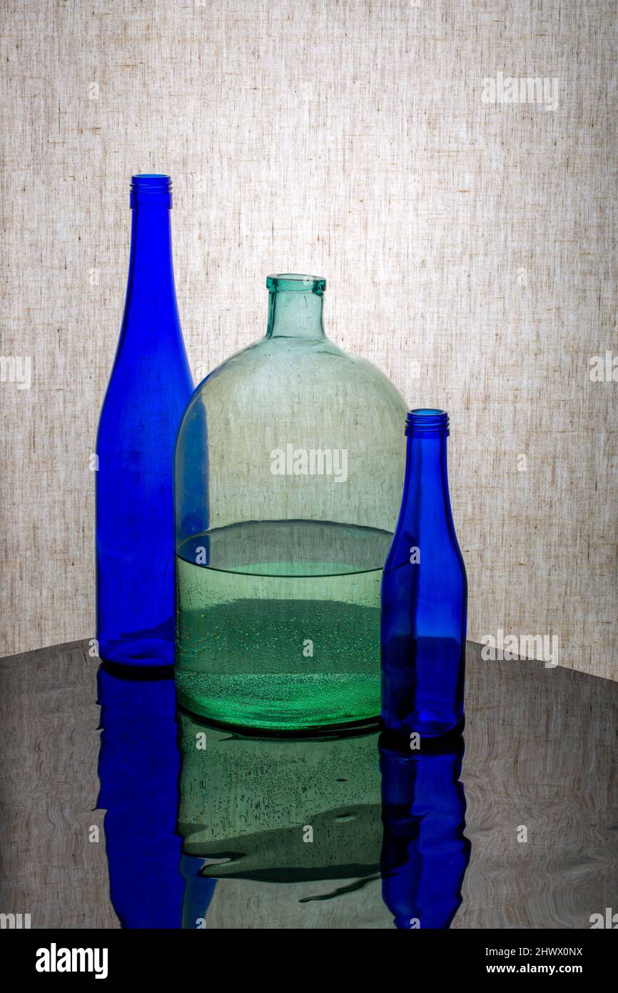 Still life with blue bottles and a jar with water Stock Photo - Alamy