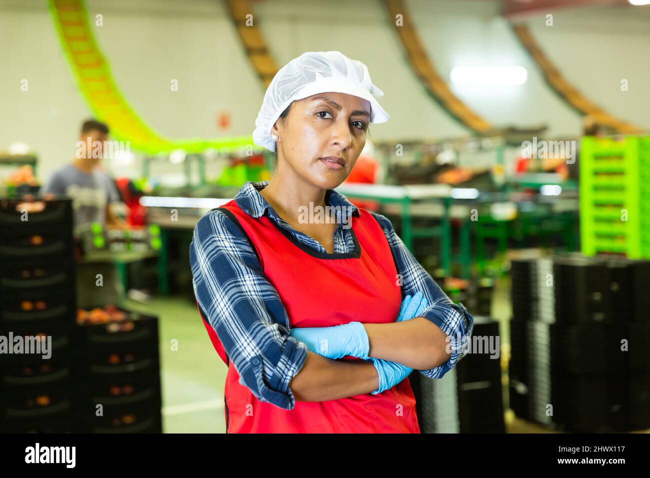 Latino woman worker standing at fruit warehouse Stock Photo - Alamy
