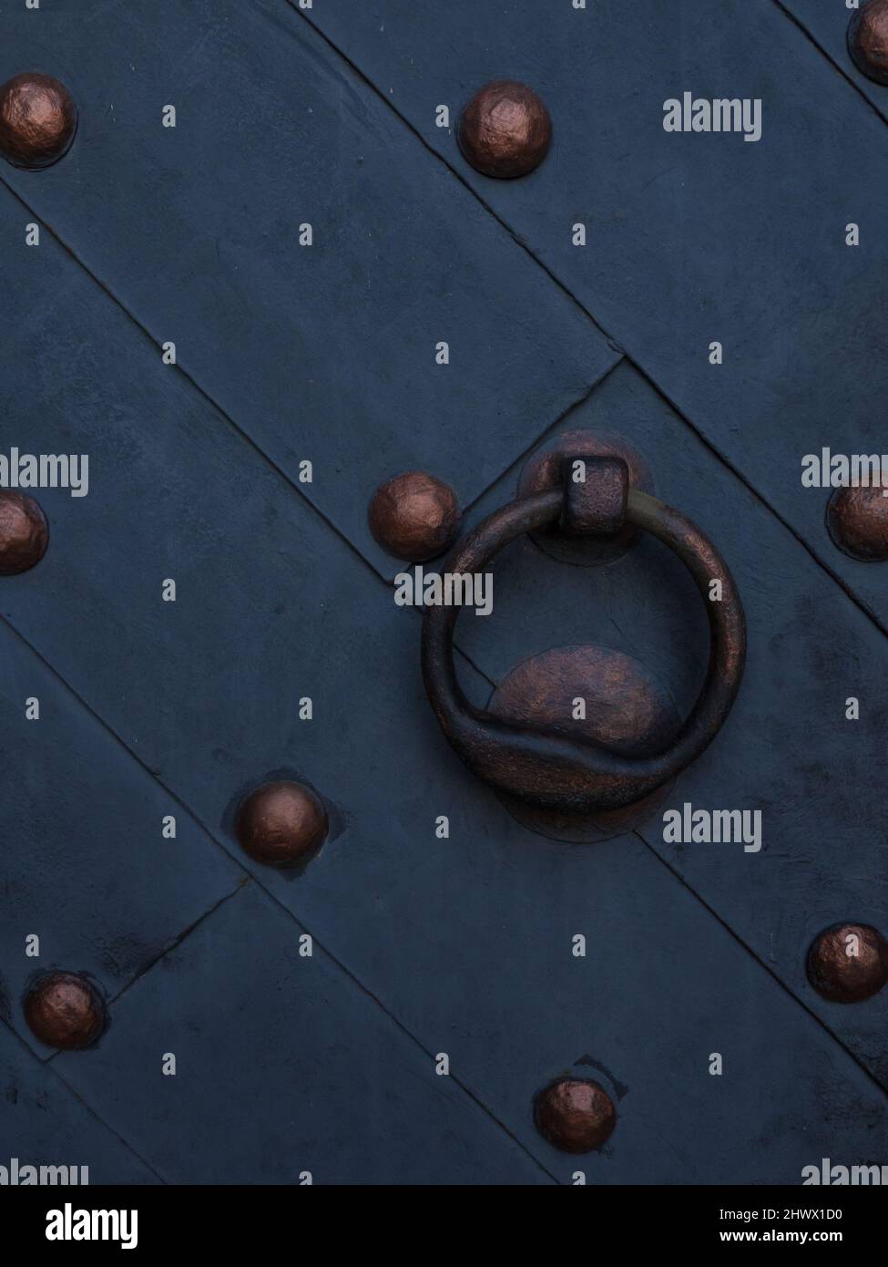 A strong black wooden door with heavy brown rivets Stock Photo - Alamy