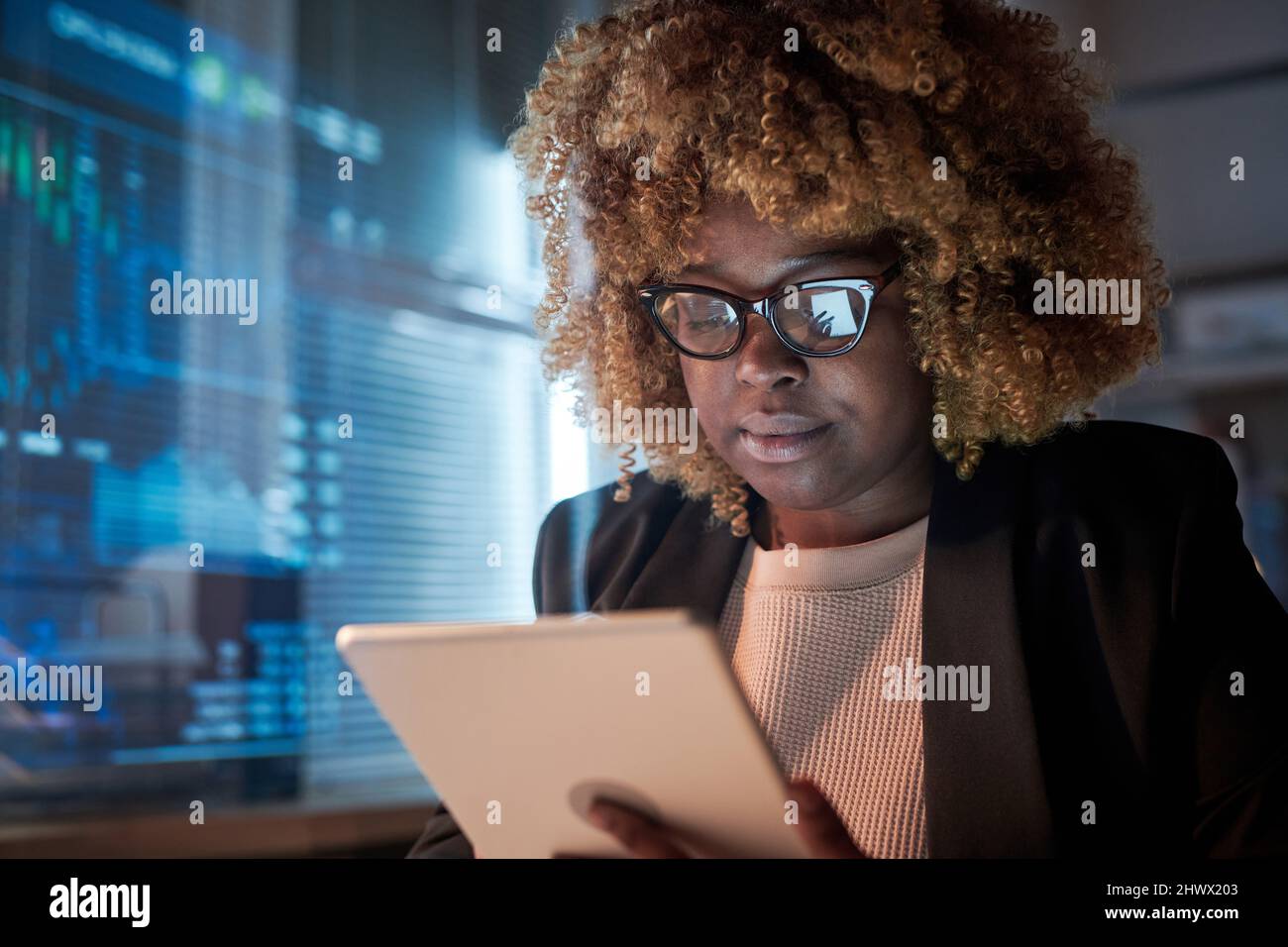 African female programmer with curly hair wearing eyeglasses developing ...